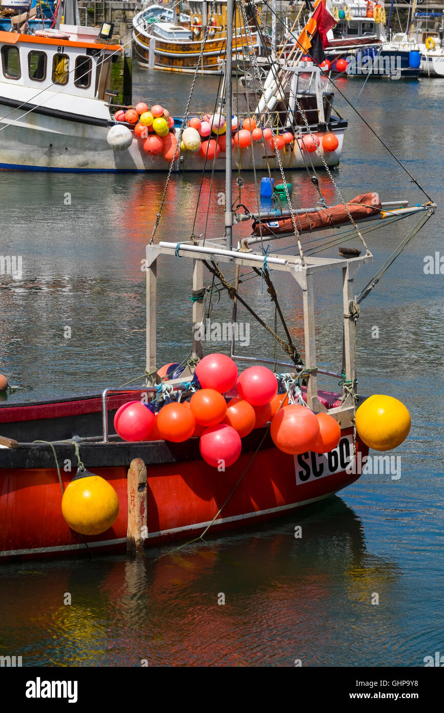 Brightly coloured floats on fishing boats in Mevagissey Harbour ...