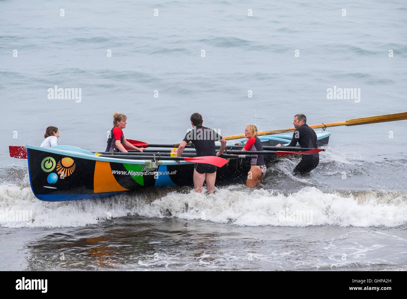 A rowing team with a gig boat on the beach at Trevaunance Cove, St ...