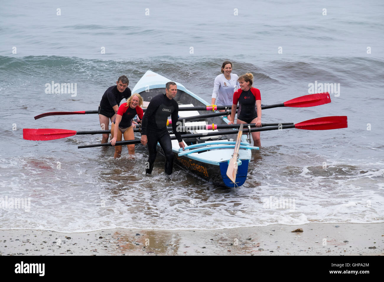 A rowing team with a gig boat on the beach at Trevaunance Cove, St ...