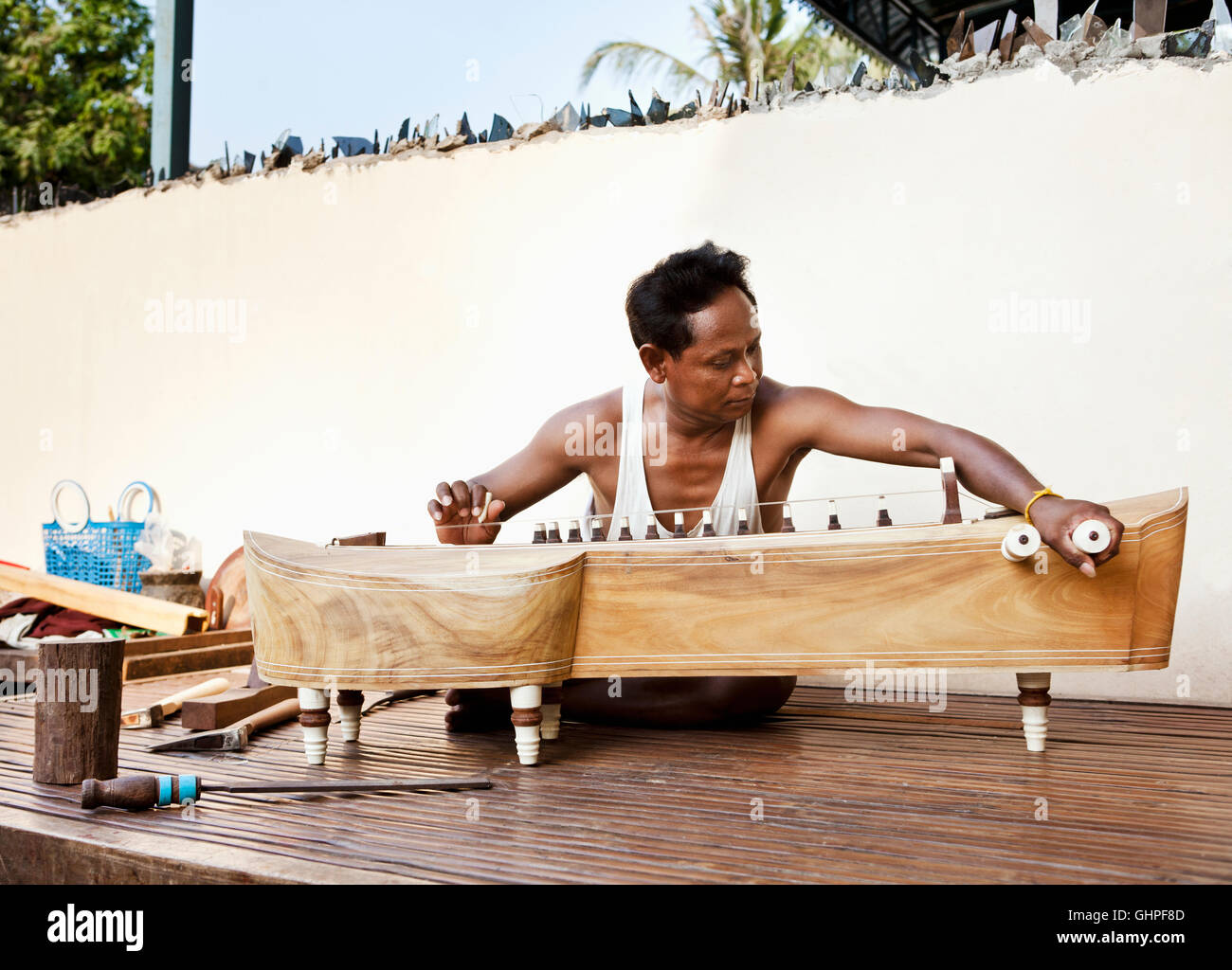 Instrument maker, Meas Mary makes a Takhe at his home in Boeng Tompu ...