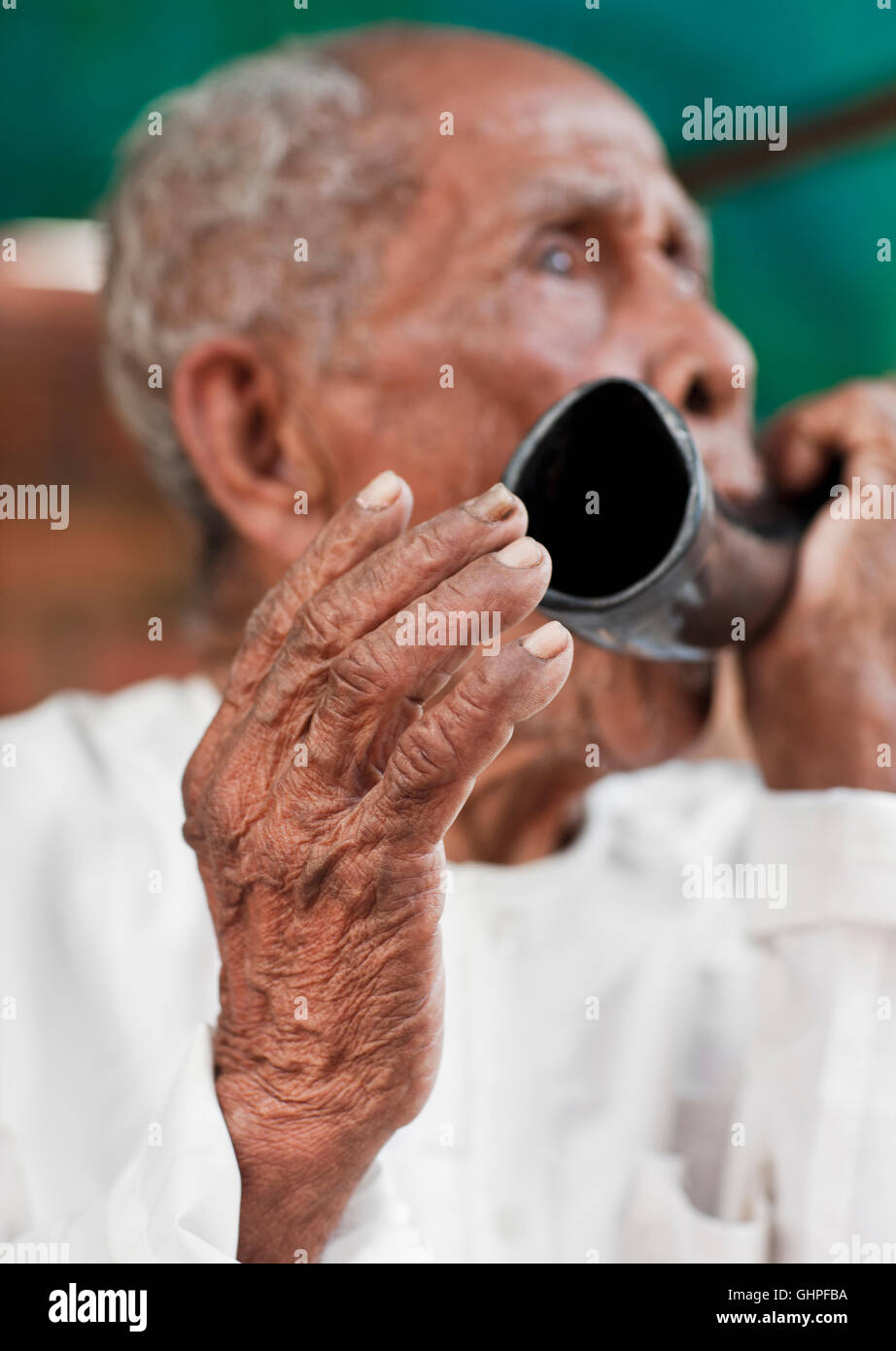 Master Musician Yim Saing plays a Khmer horn ( snaeng) at his home in ...