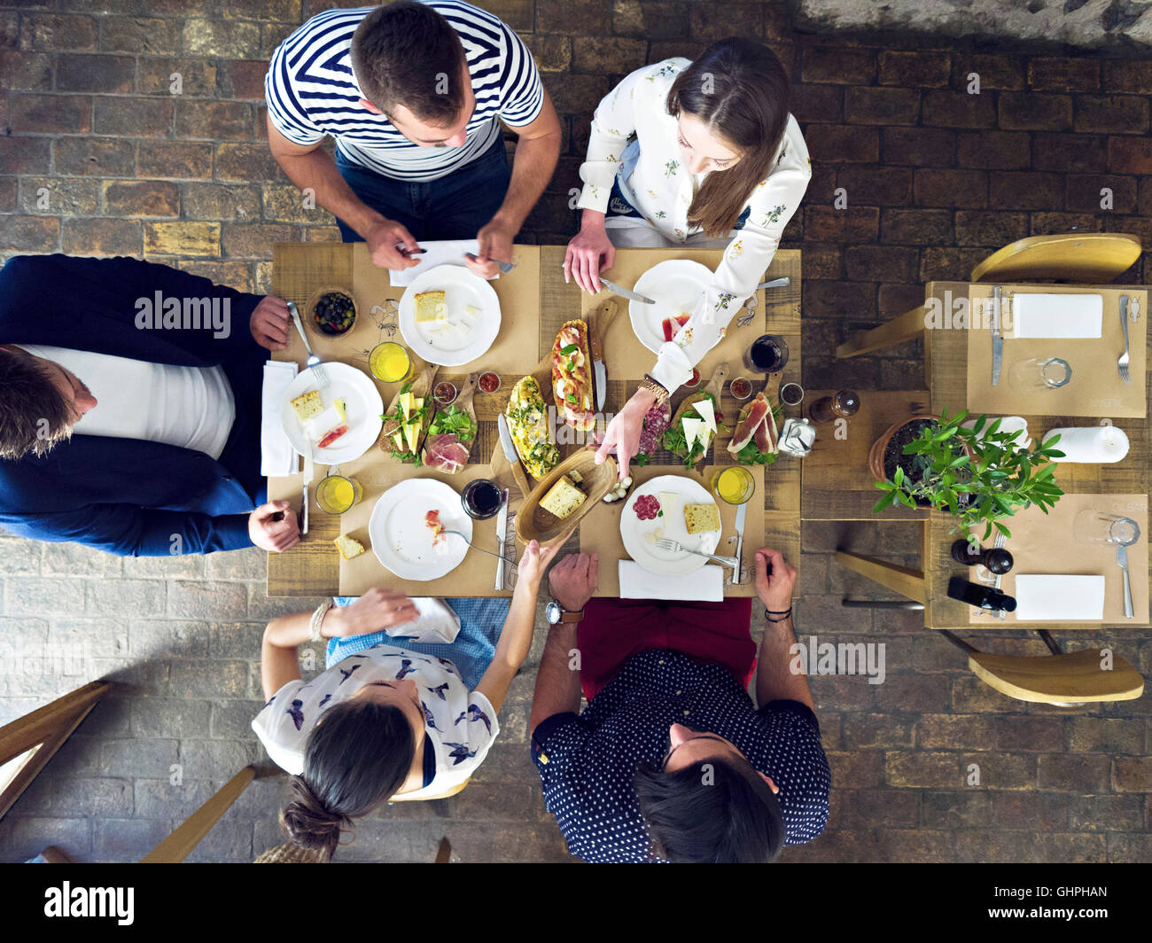 Group of friends having lunch in restaurant Stock Photo - Alamy