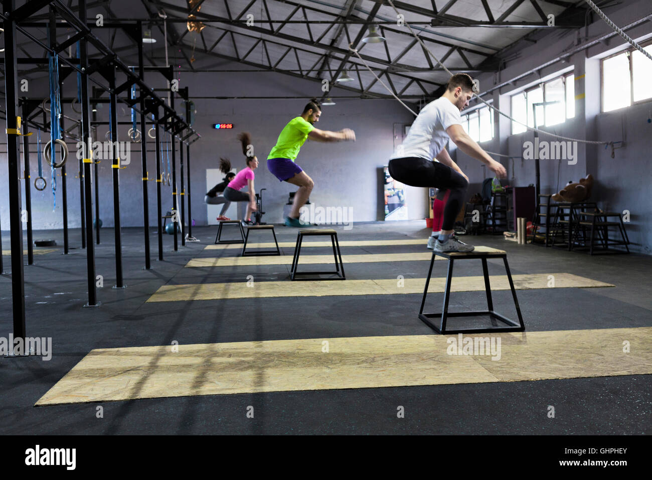 Athletes doing box jumps in gym Stock Photo - Alamy