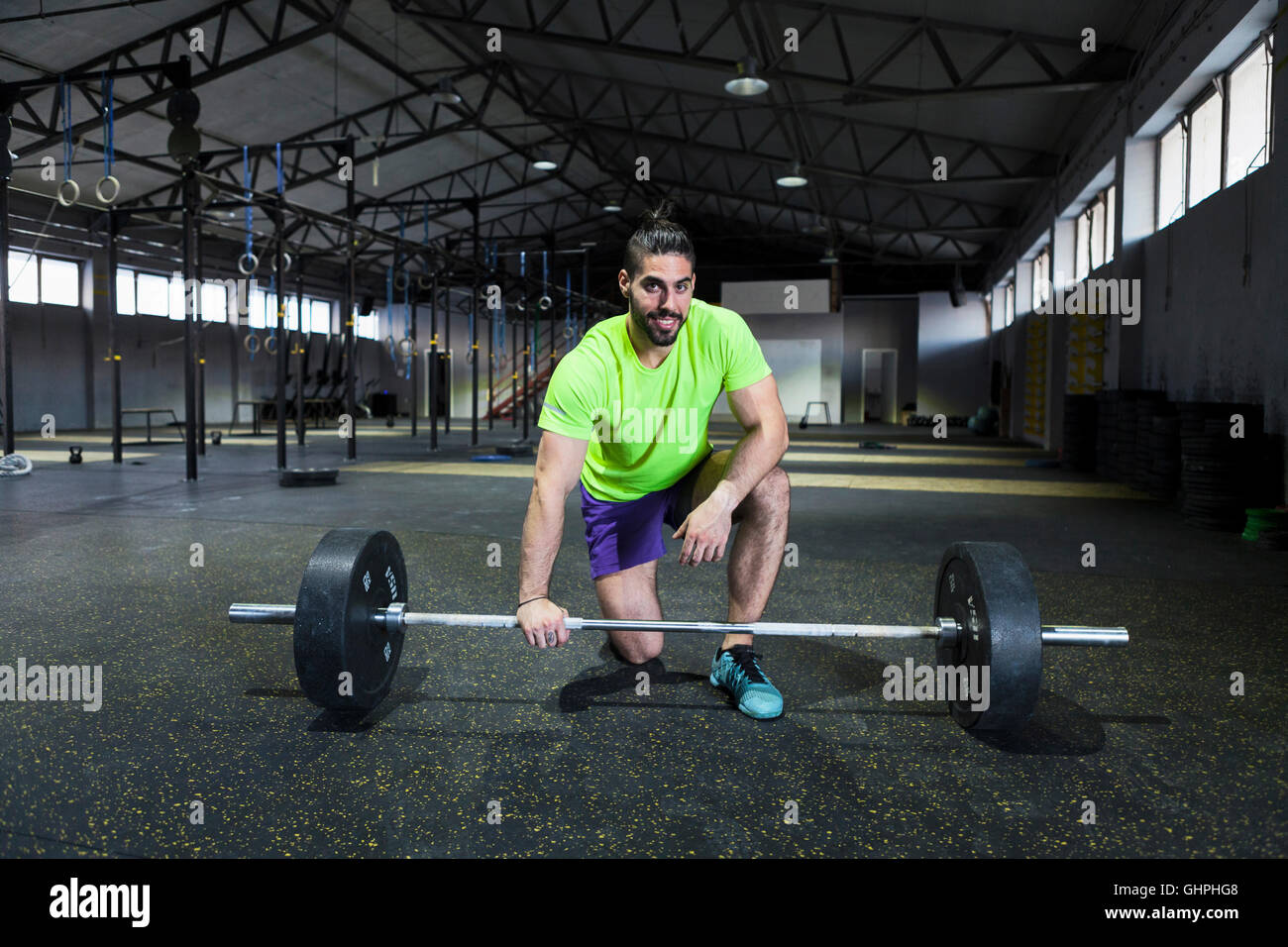 Athlete in gym prepares for lifting a barbell Stock Photo - Alamy