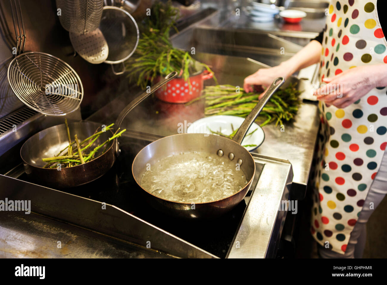 Female chef preparing food in frying pan Stock Photo - Alamy