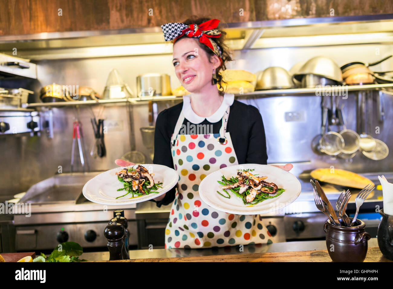 Female chef in restaurant serving fresh calamari dish Stock Photo - Alamy
