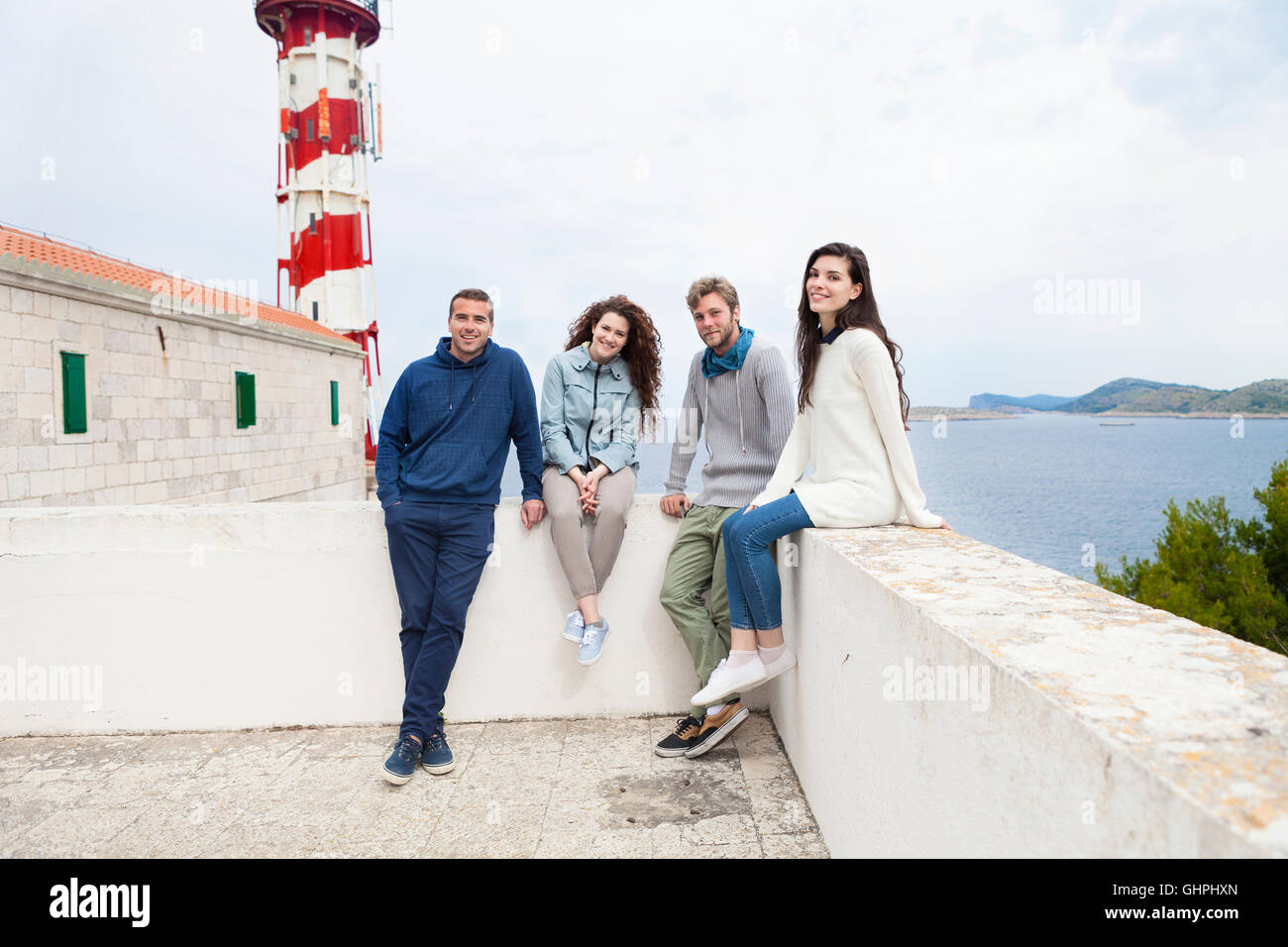 Group of friends with lighthouse in background Stock Photo - Alamy