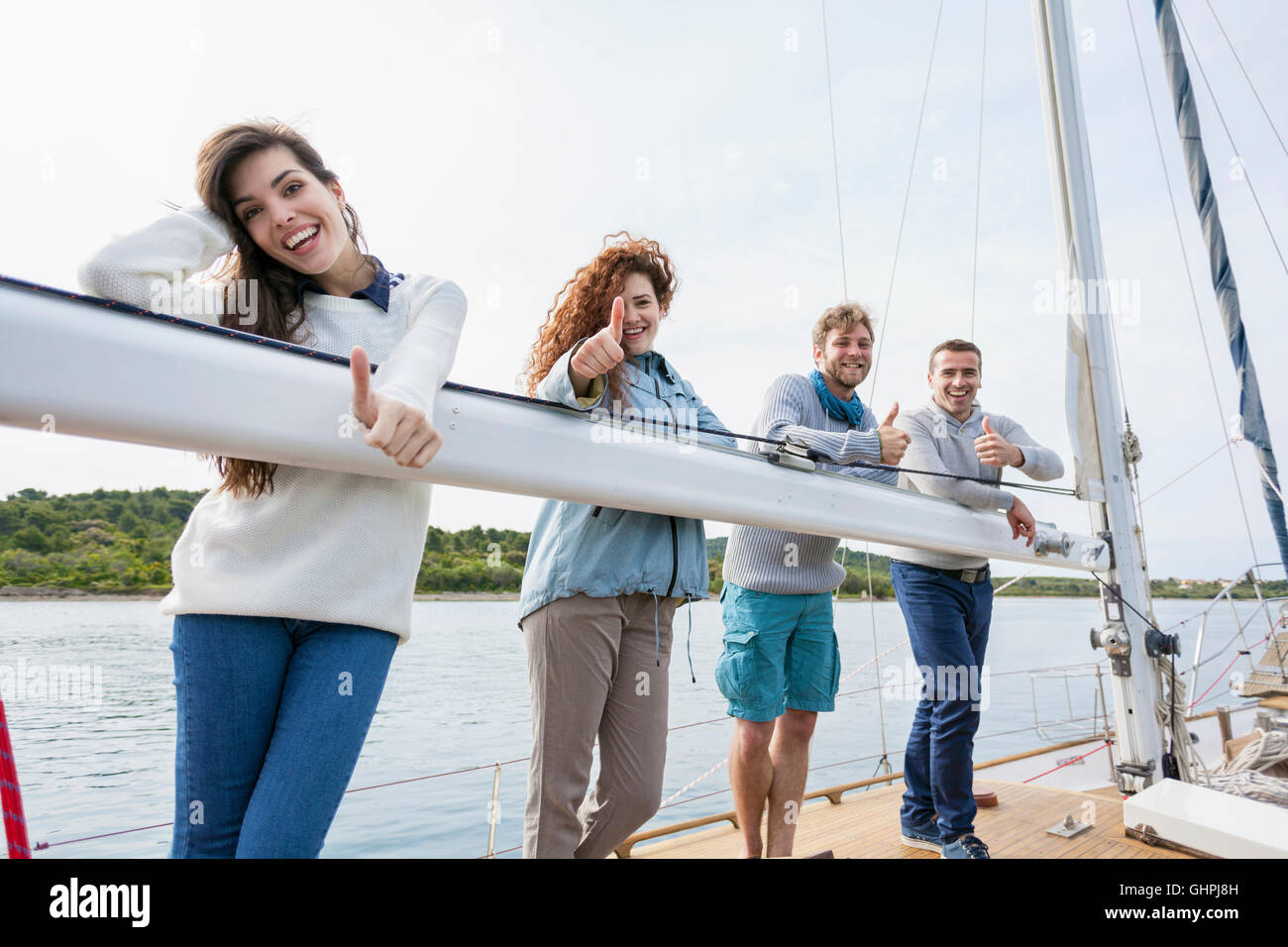 Friends on yacht giving the thumbs-up Stock Photo - Alamy