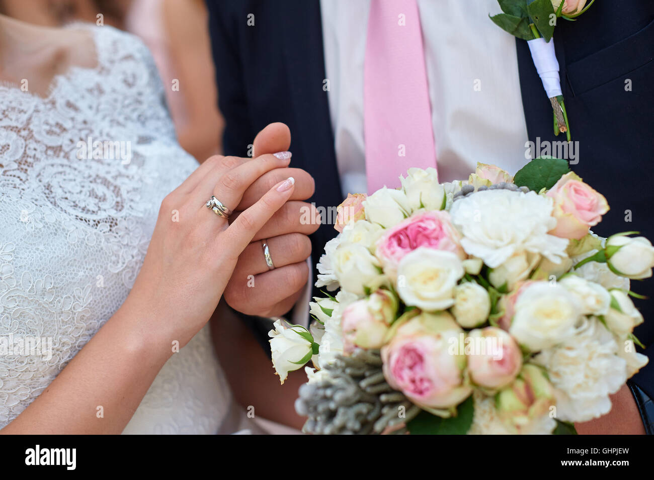 bride and groom holding hands with bridal bouquet Stock Photo - Alamy