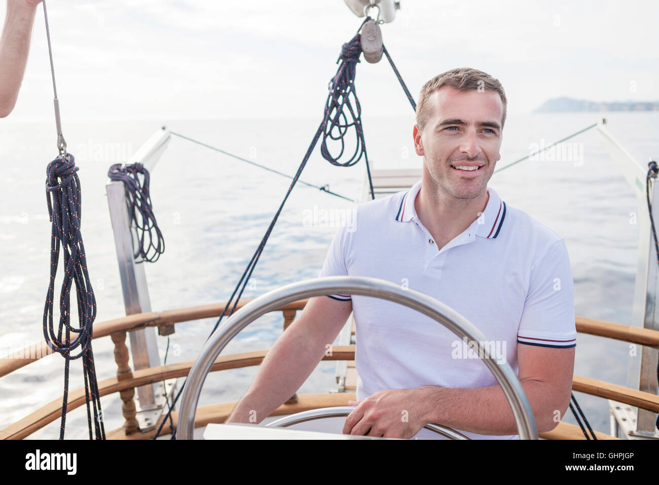Man steering wheel of sailboat Stock Photo - Alamy