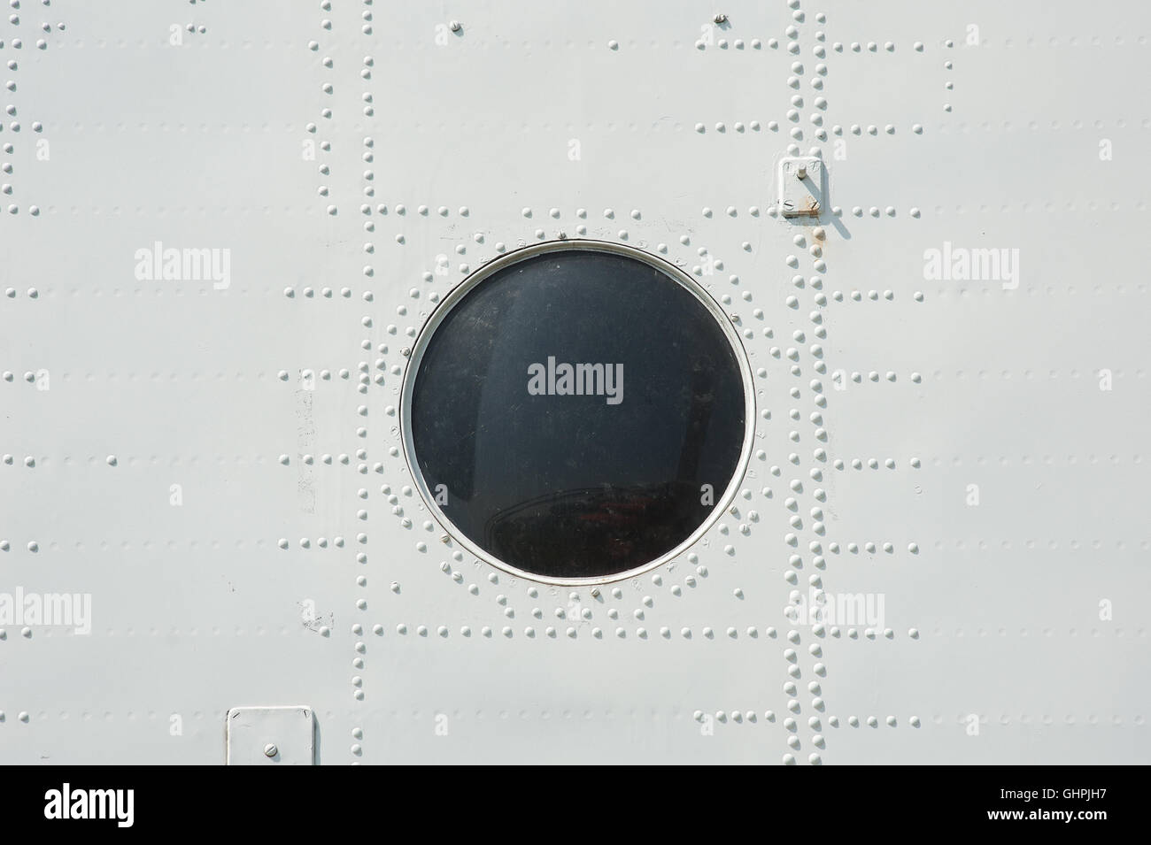 photographed close-up of metal siding and porthole in military plane in ...