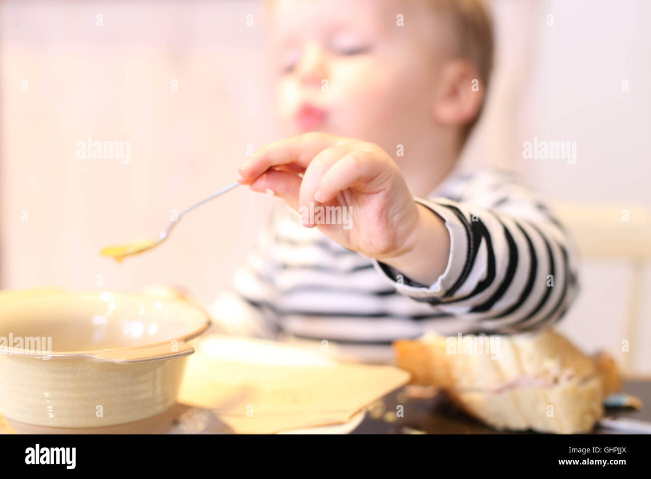 toddler boy eating soup with big spoon Stock Photo - Alamy