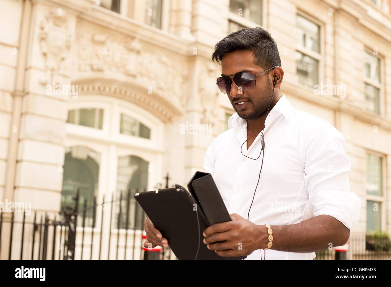 indian man in the street using an tablet Stock Photo - Alamy