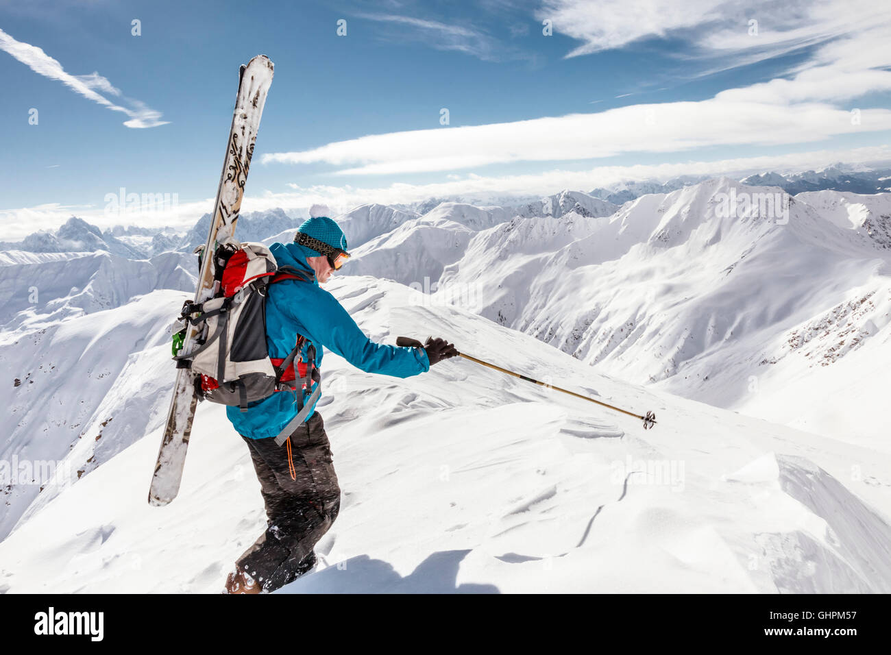 Junger Skitourengeher / Freerider am Gipfelgrat auf der Suche nach der ...