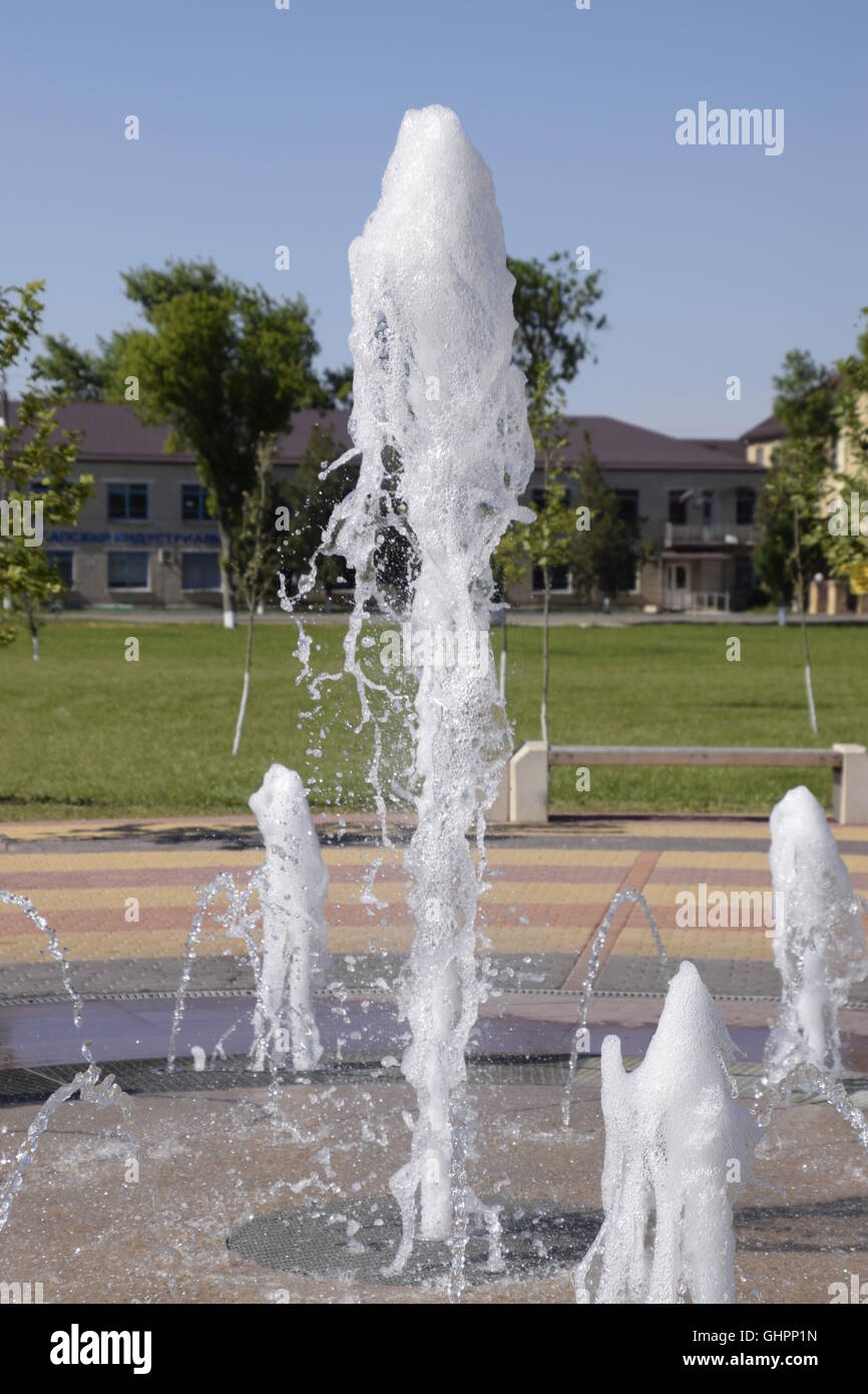 Splashes of a fountain in the park. Beautiful water jet emitted ...
