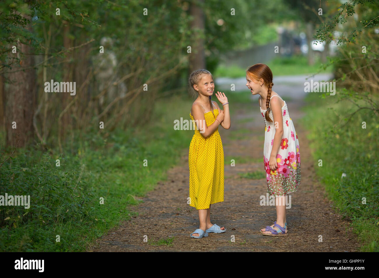 Two little girls having fun discussing standing in a Park Stock Photo ...