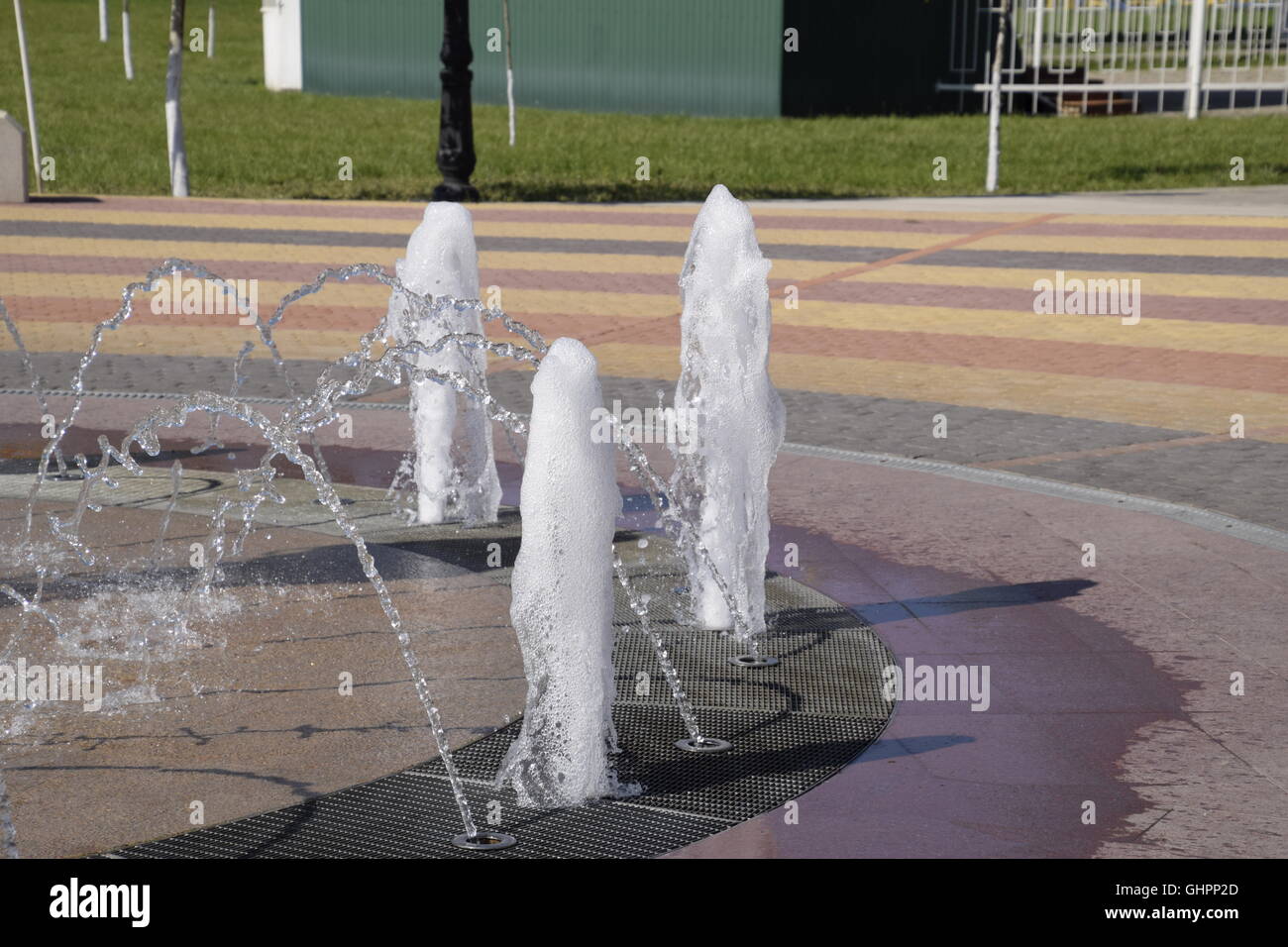 Splashes of a fountain in the park. Beautiful water jet emitted ...
