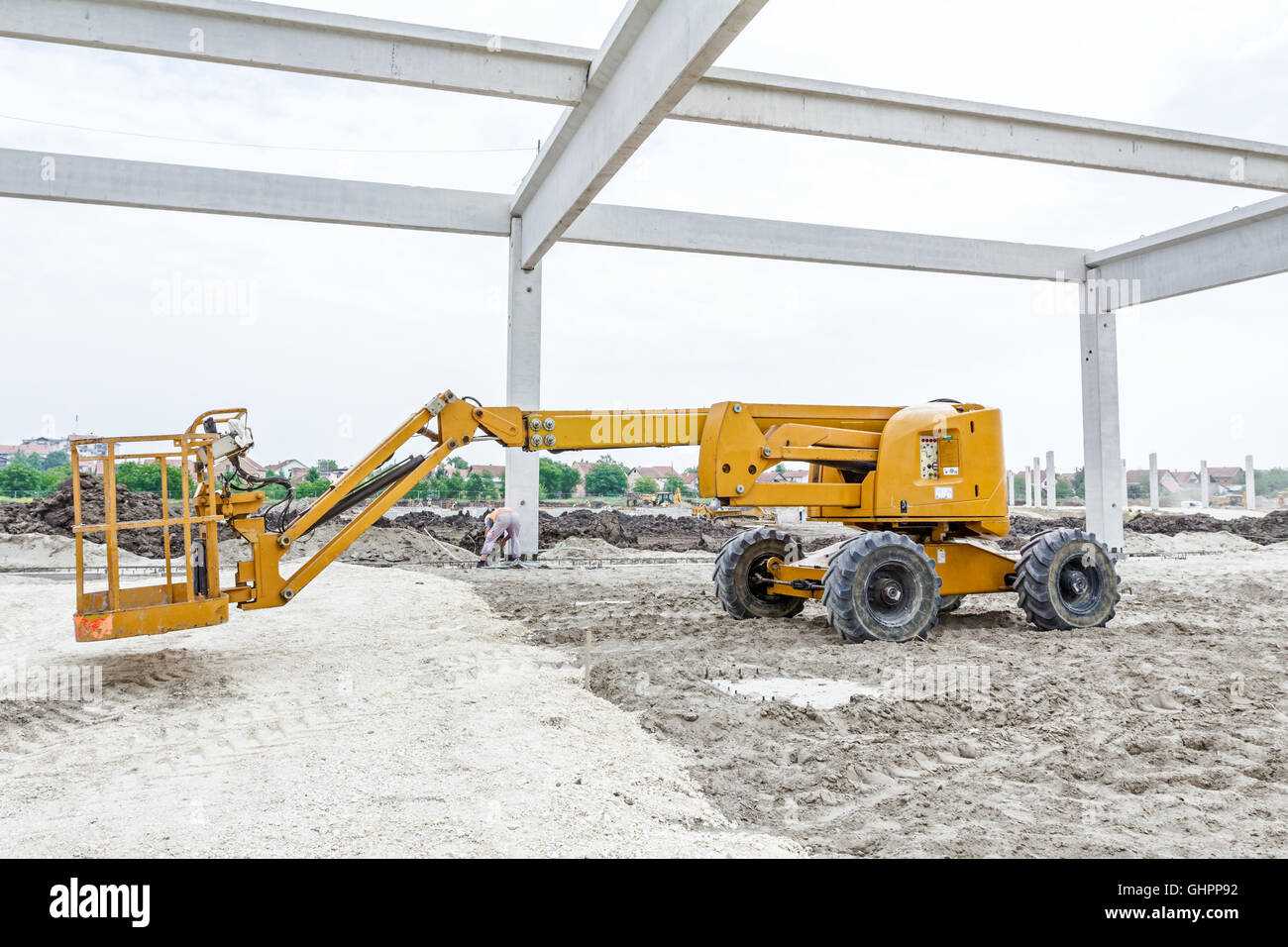 Cherry picker is parked below concrete skeleton of new assembled ...