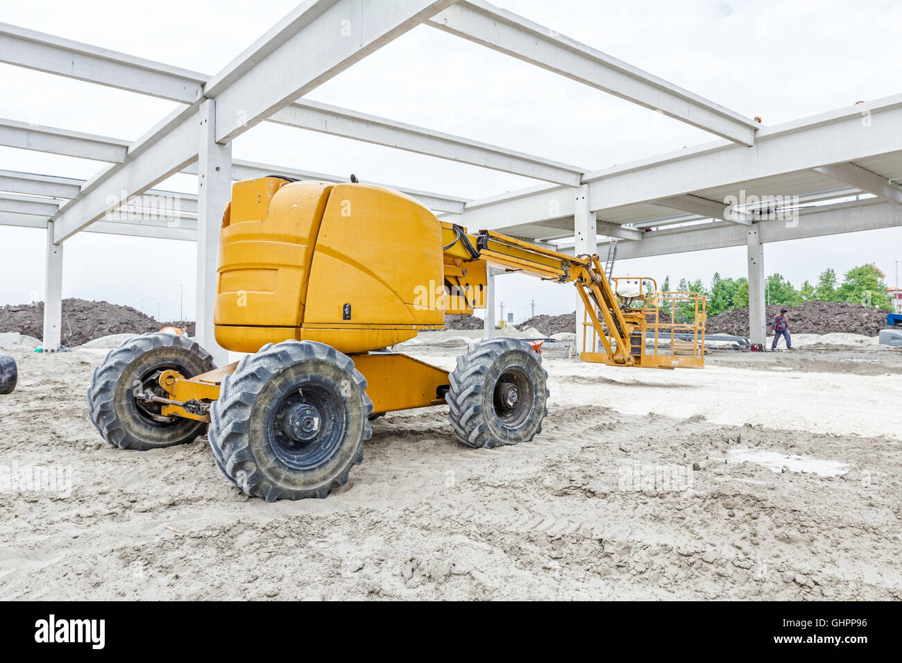 Cherry Picker is parked below concrete skeleton of new assembled ...