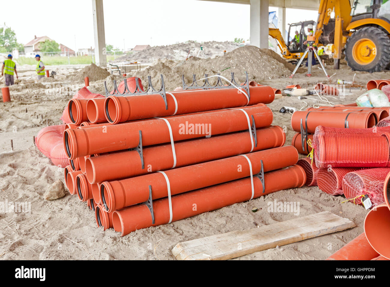 Sewer pipes waiting to be placed into the ditch at construction site ...