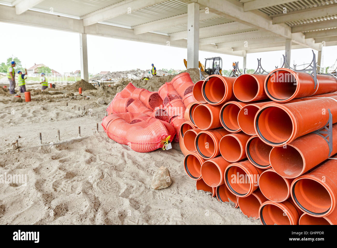 Sewer pipes waiting to be placed into the ditch at construction site ...