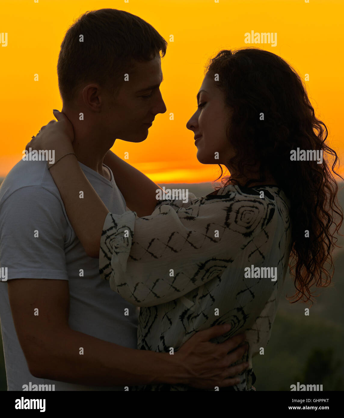Couple embrace on hill sunset hi-res stock photography and images - Alamy