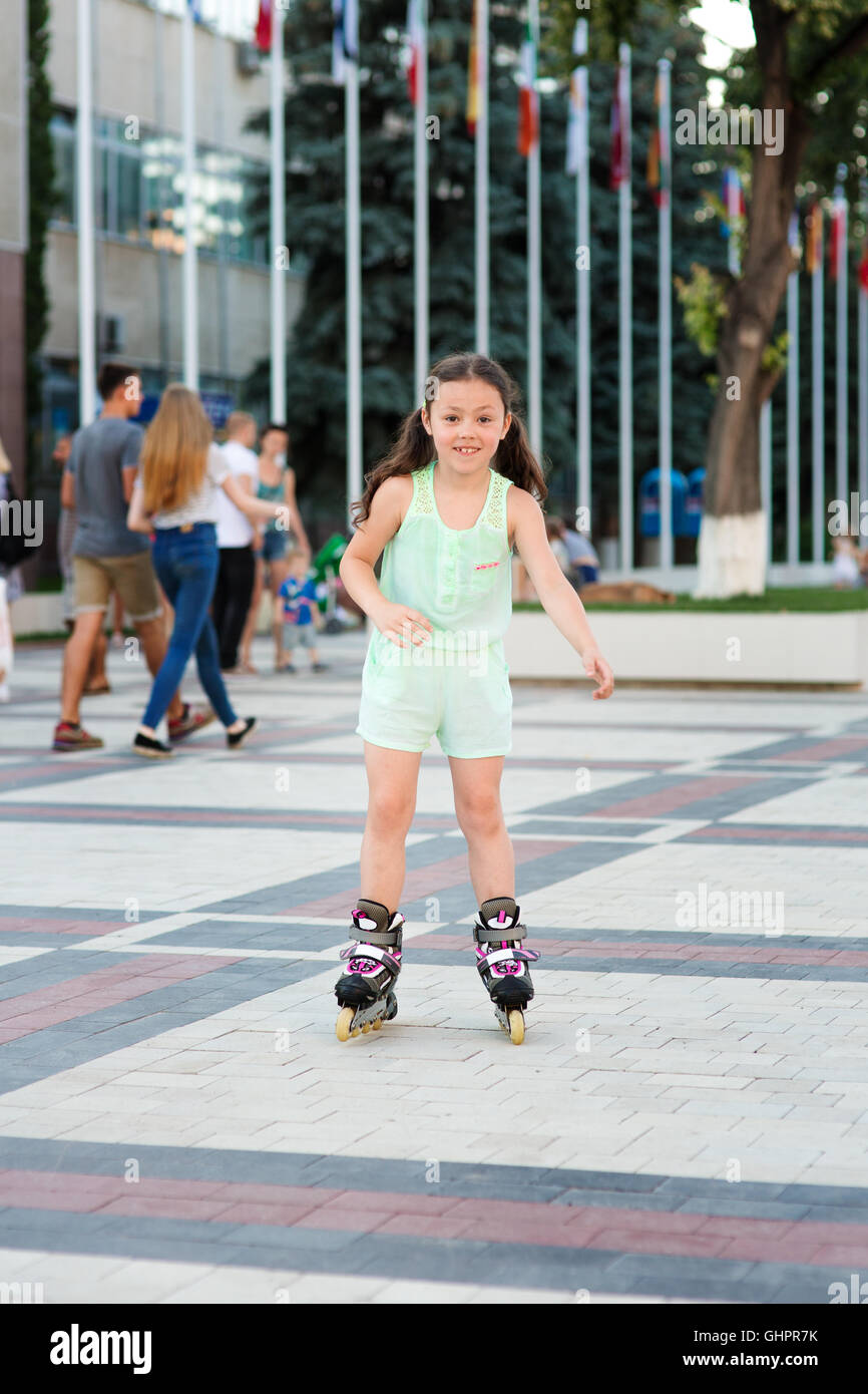 Little pretty girl rides on roller skates at a park on sunset Stock ...