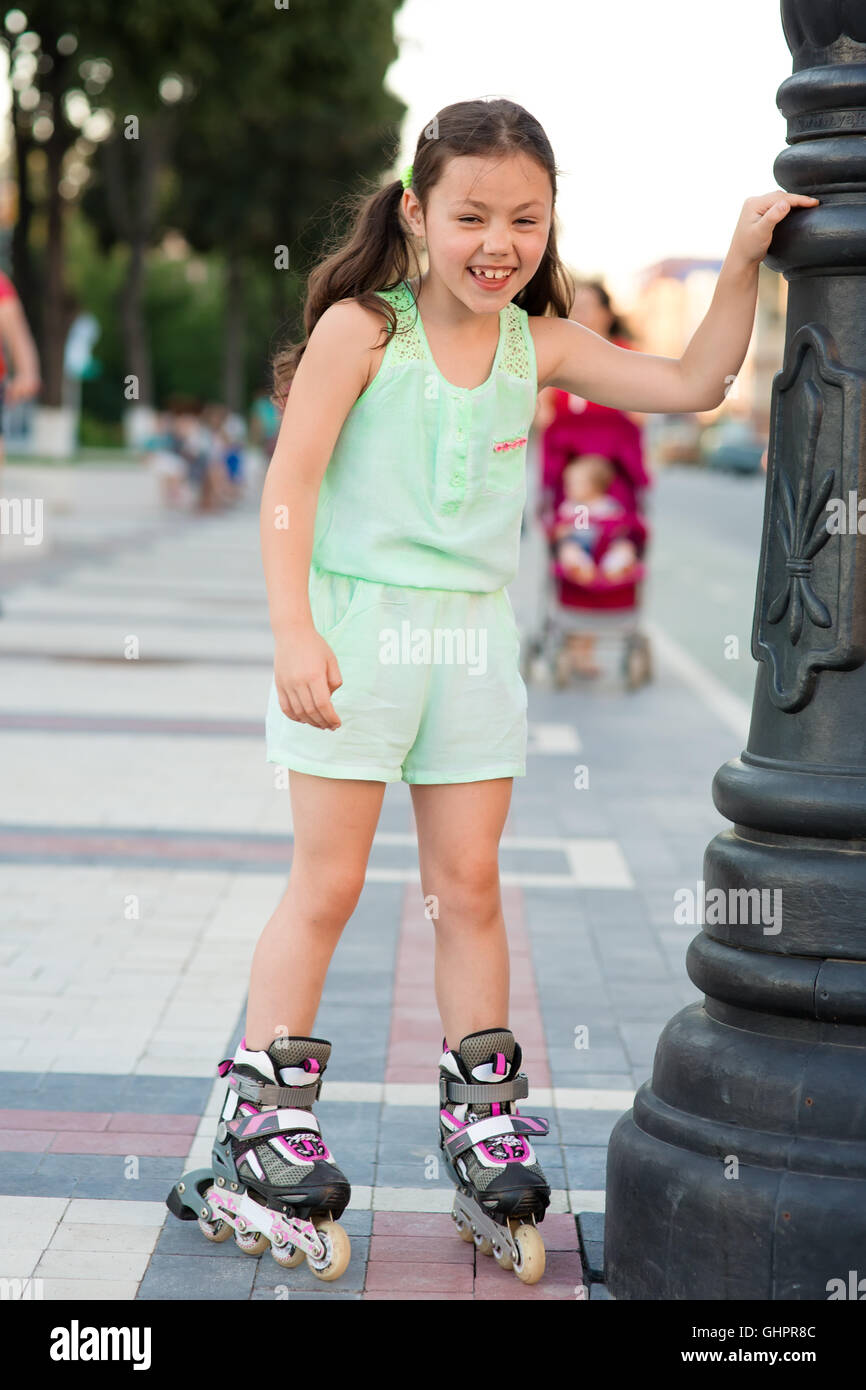 Little pretty girl rides on roller skates at a park on sunset Stock ...