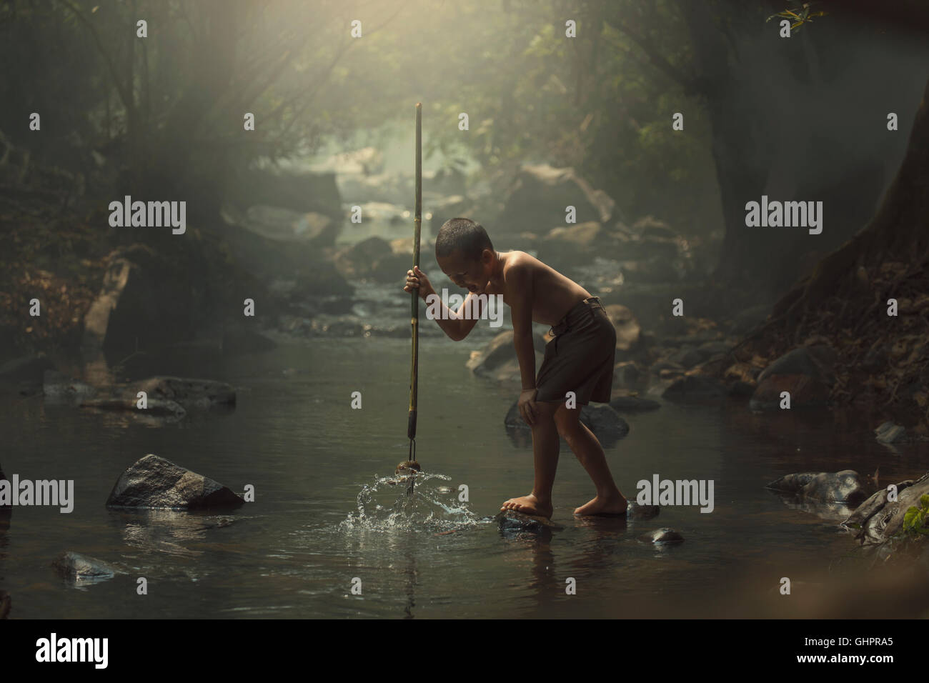 Fisher boy hunter on the creek forest Stock Photo - Alamy