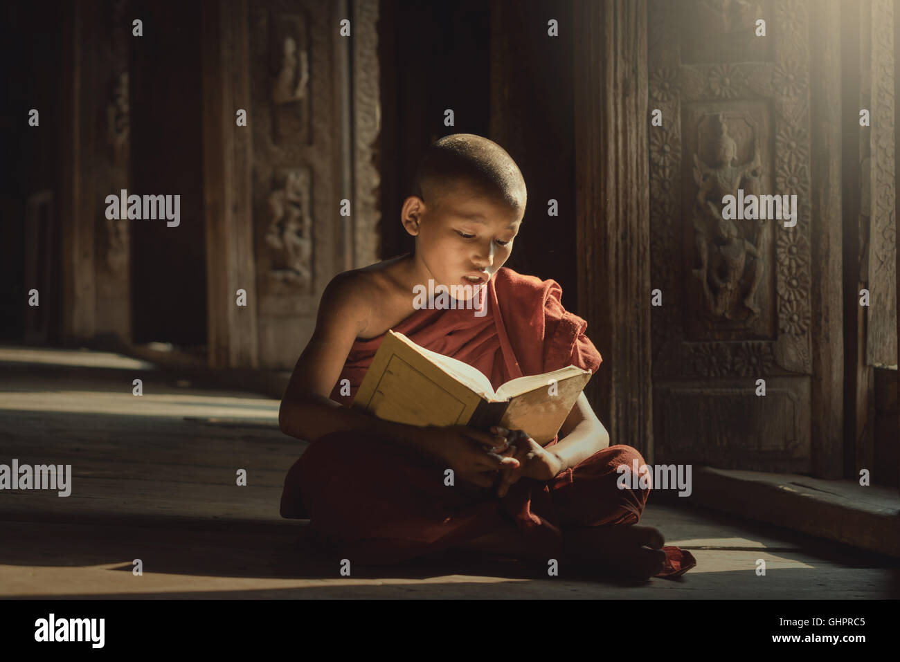 Novice reading book with lighting in temple,Mandalay,Myanmar Stock ...