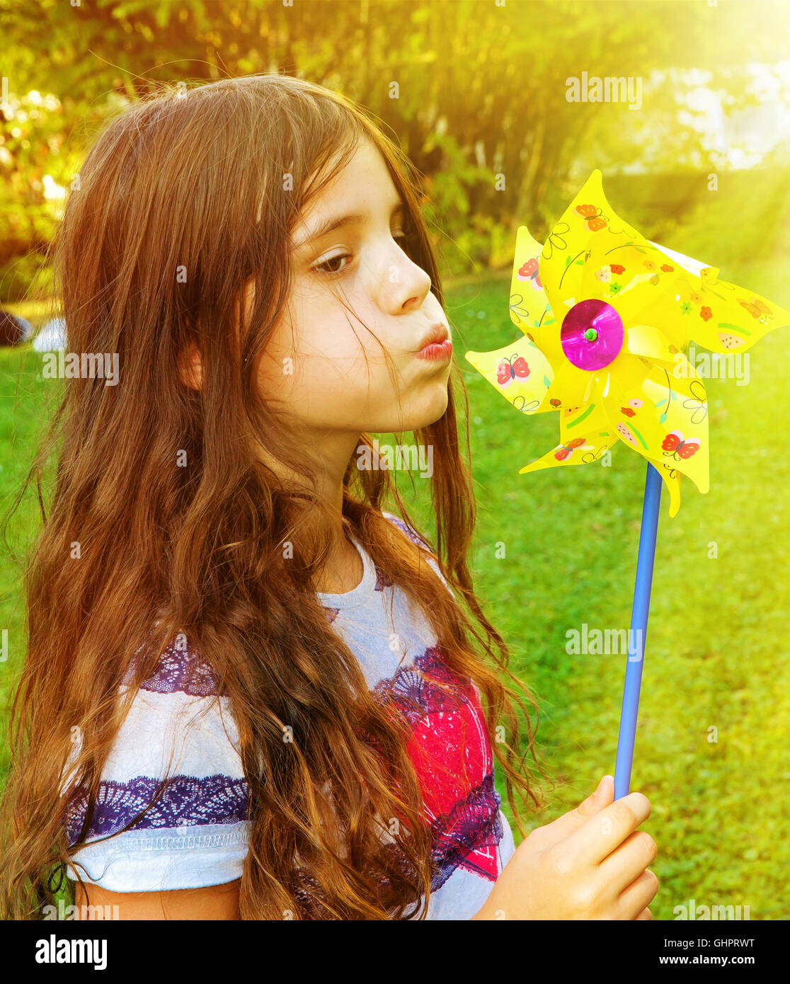 Little girl blowing on a windmill Stock Photo - Alamy