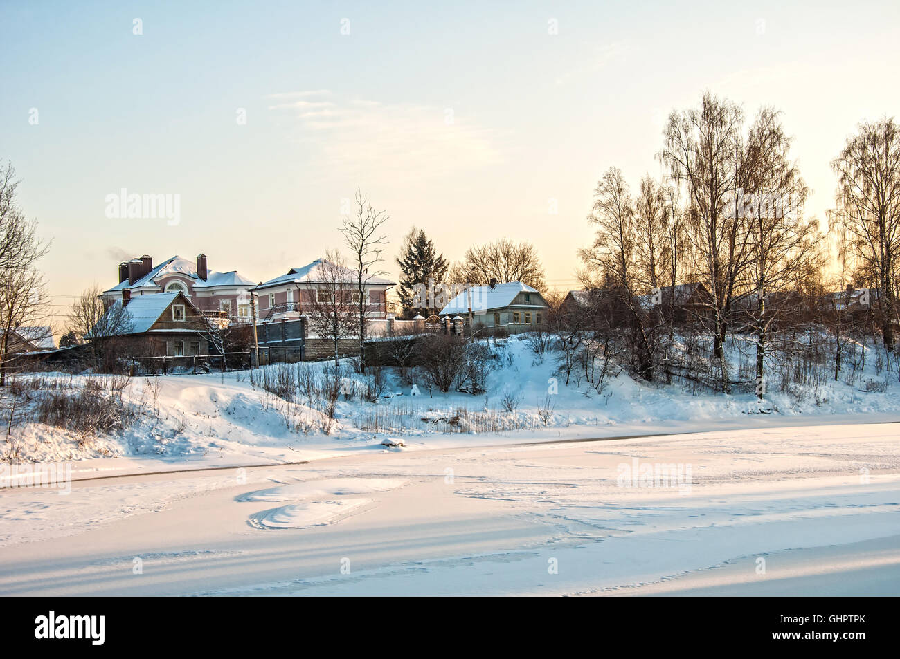 Winter evening. Houses on the river Bank Stock Photo - Alamy