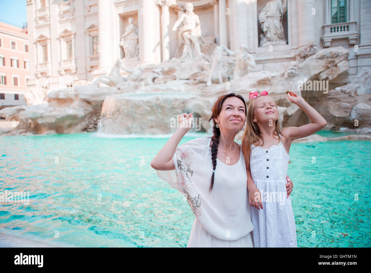 Travel family mom and girl trowing coin at Trevi Fountain, Rome, Italy ...