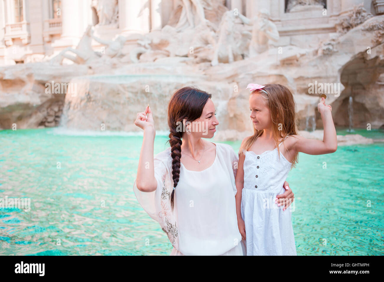 Travel family mom and girl trowing coin at Trevi Fountain, Rome, Italy ...