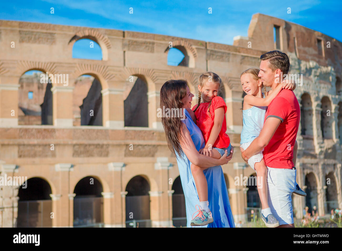 Happy family in Europe. Parents and kids in Rome over Coliseum ...