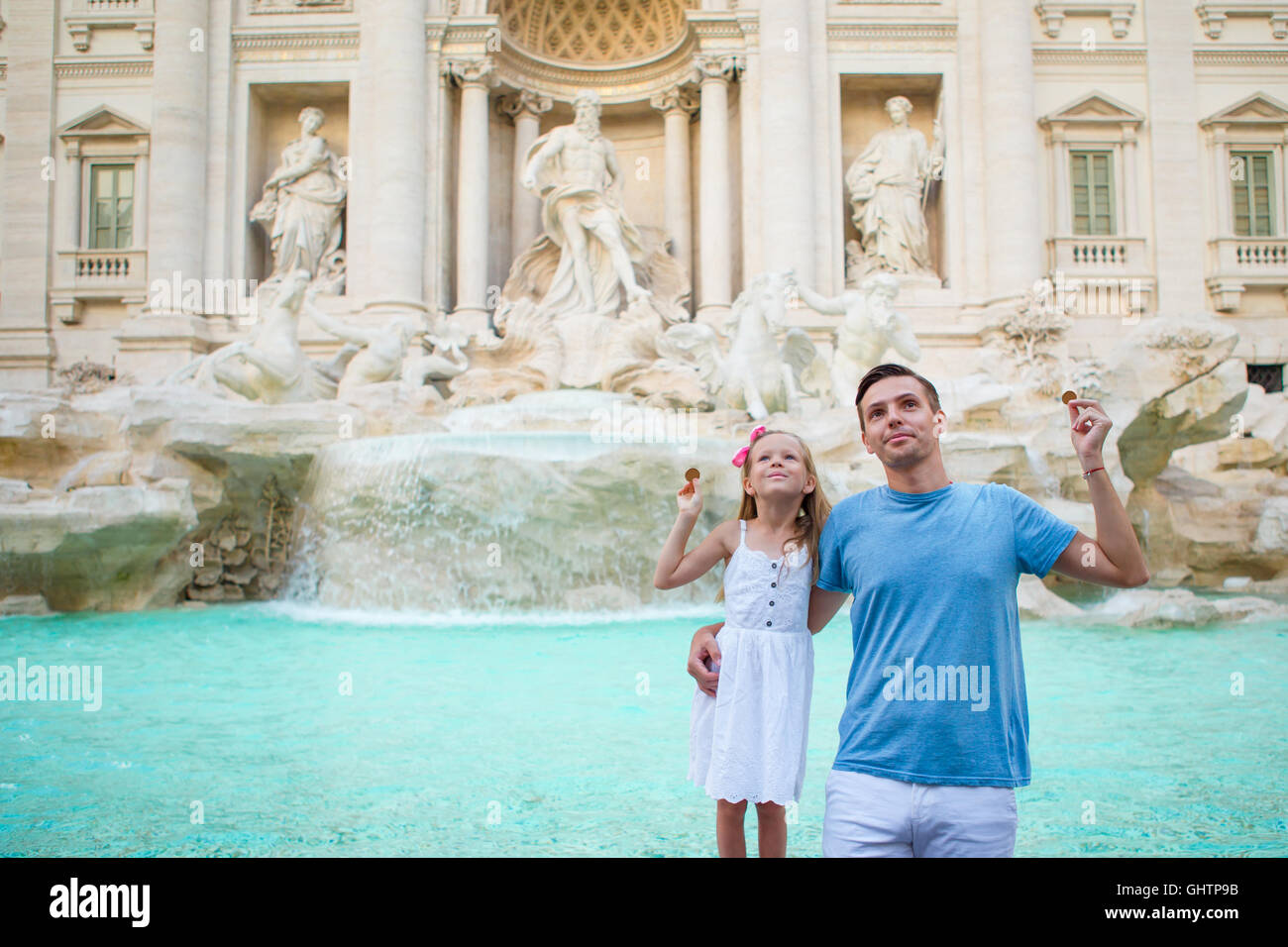 Happy family trowing coins at Trevi Fountain, Rome, Italy for good luck ...