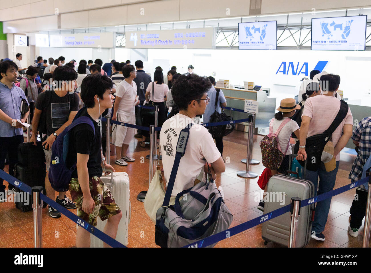 Tokyo, Japan. 11th August, 2016. Passengers queue at a check-in desk at ...