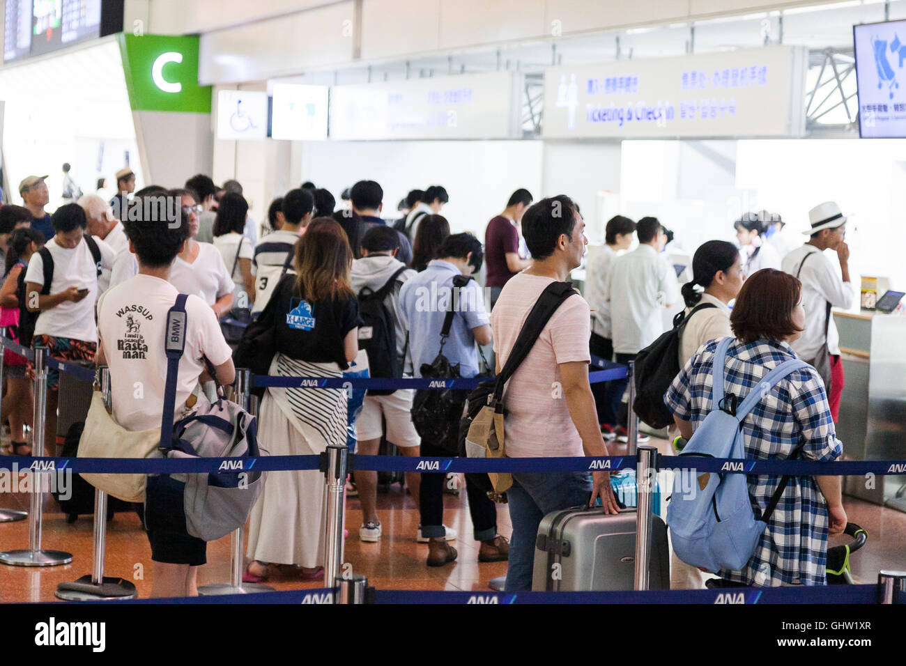 Tokyo, Japan. 11th August, 2016. Passengers queue at a check-in desk at ...