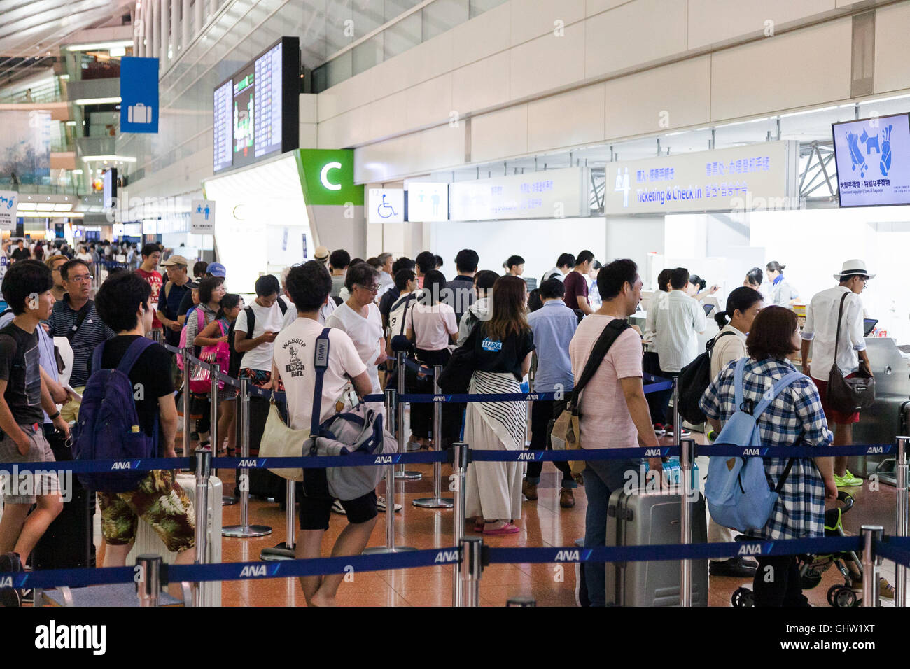 Tokyo, Japan. 11th August, 2016. Passengers queue at a check-in desk at ...