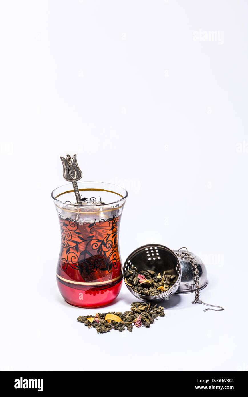 Typical Turkish glass for tea with a teaspoon and tea inside and an ...