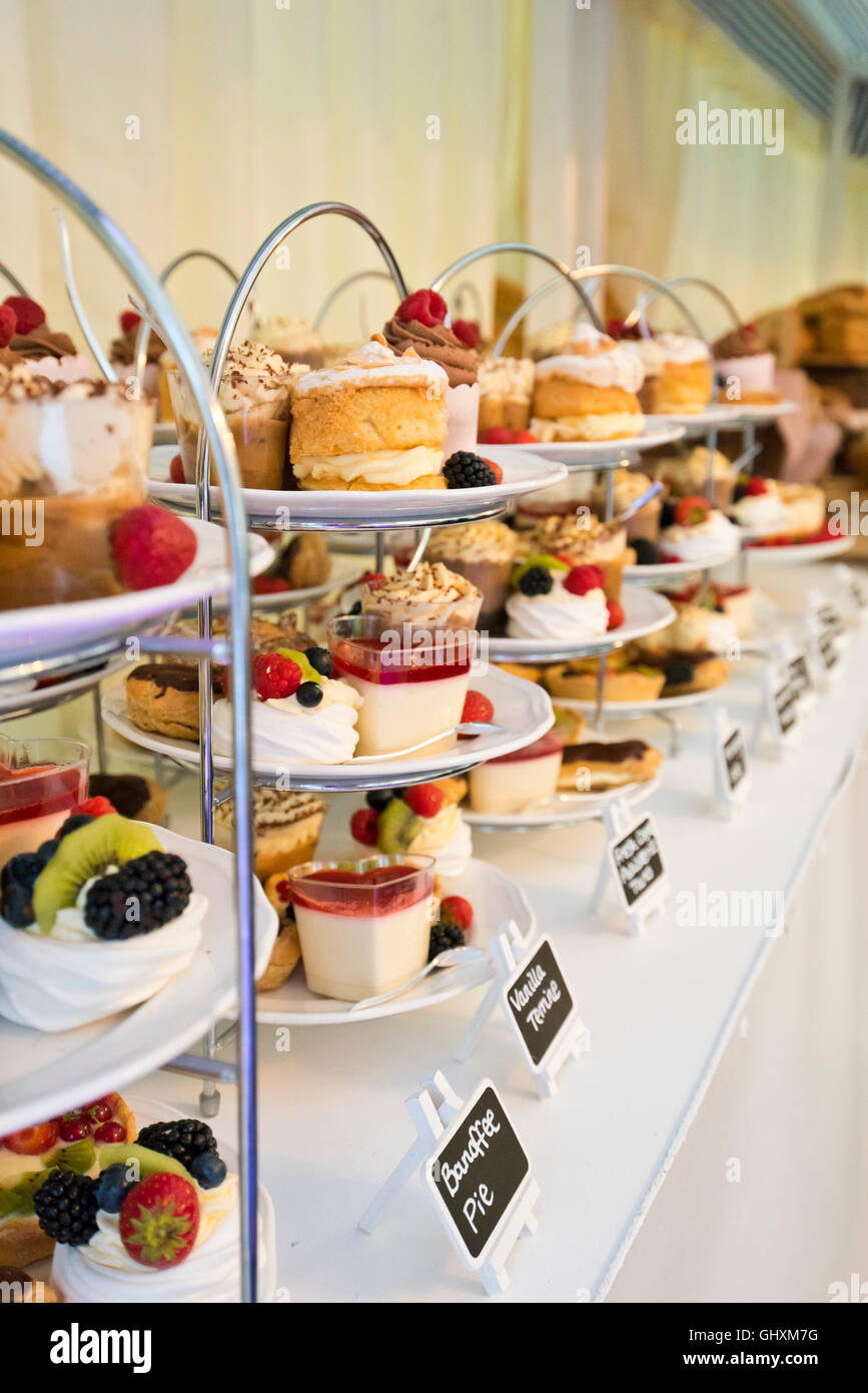 Vertical view of cakes and pastries arranged on cake stands at a ...