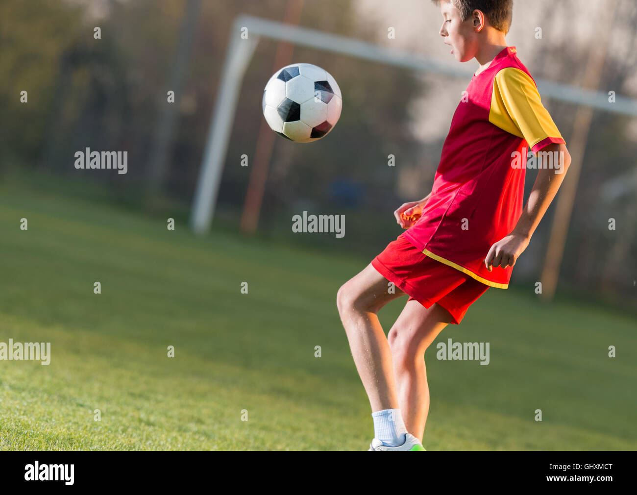 Child playing football on a soccer field Stock Photo - Alamy