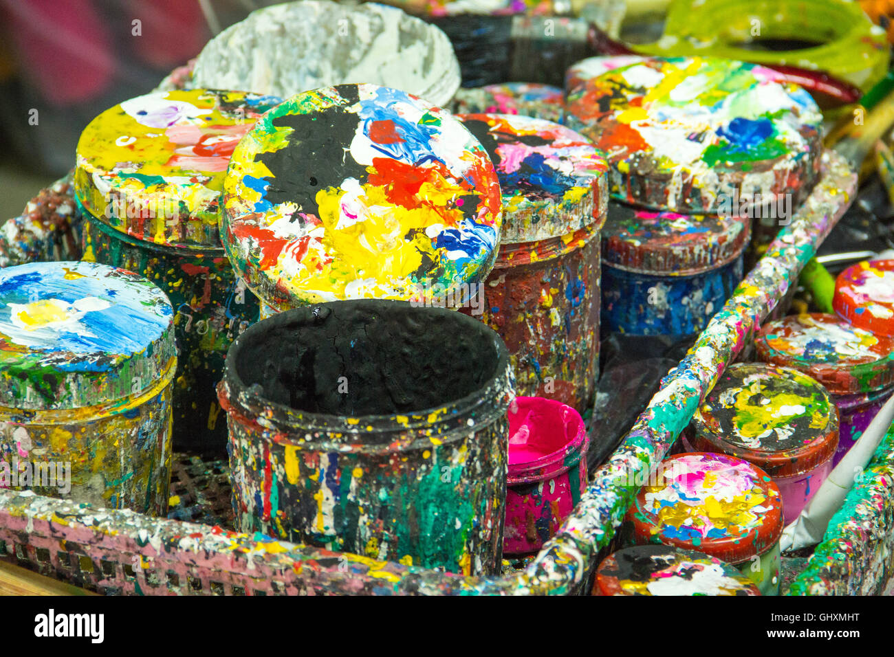 Paint-splattered tins of artist's paints and brushes Stock Photo - Alamy