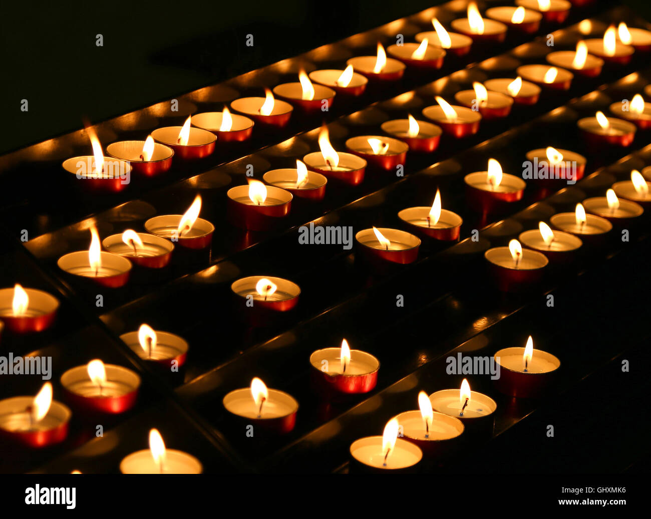 many candles lit inside the place of worship to pray Stock Photo - Alamy