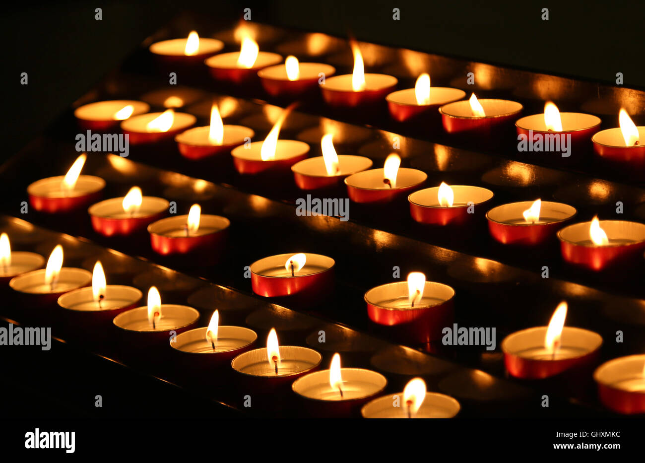 many candles lit with flickering flame in the sanctuary Stock Photo - Alamy