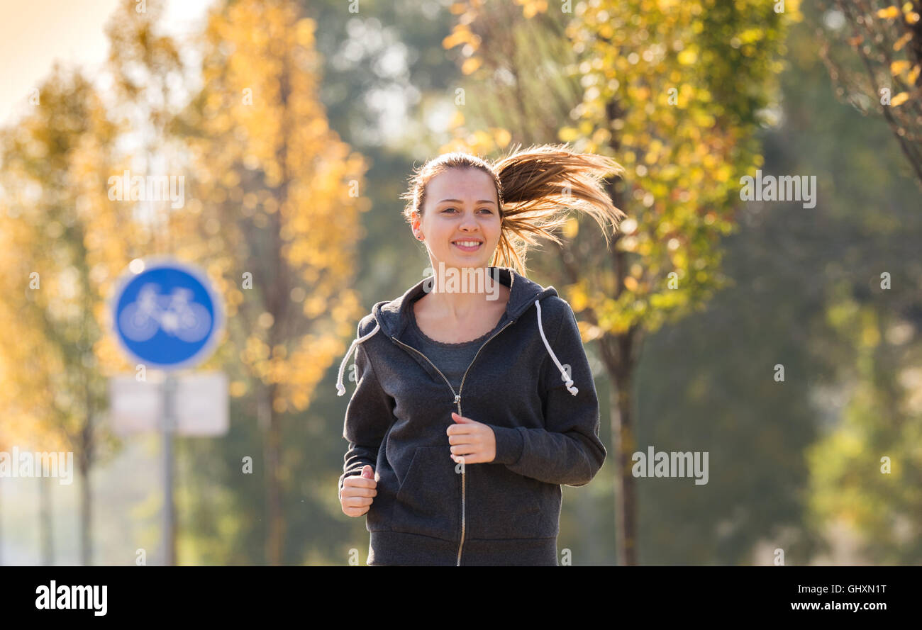 Young girl jogging in the park Stock Photo - Alamy
