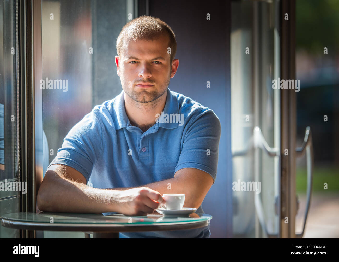 Young man drinking coffee in a cafe Stock Photo - Alamy Young man drinking coffee in a cafe Stock Photo - Alamy