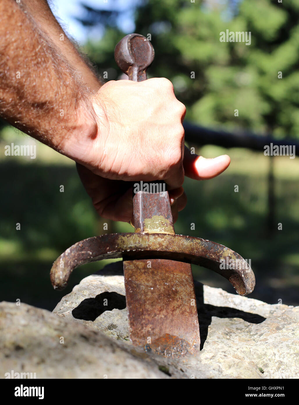 hand of a blockbuster Knight and the Excalibur sword in the stone Stock ...