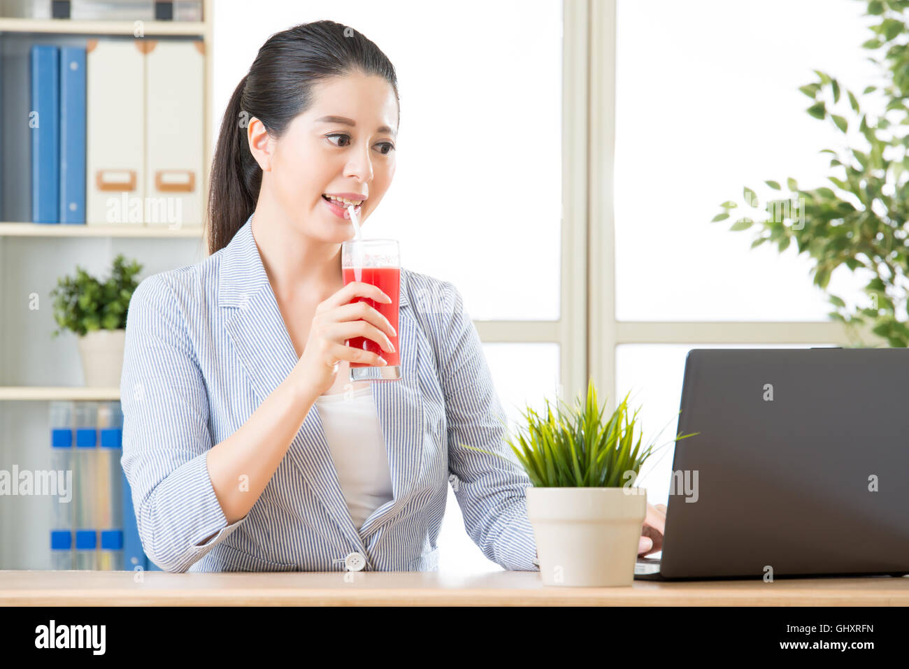 asian business woman drinking watermelon juice and use computer for ...