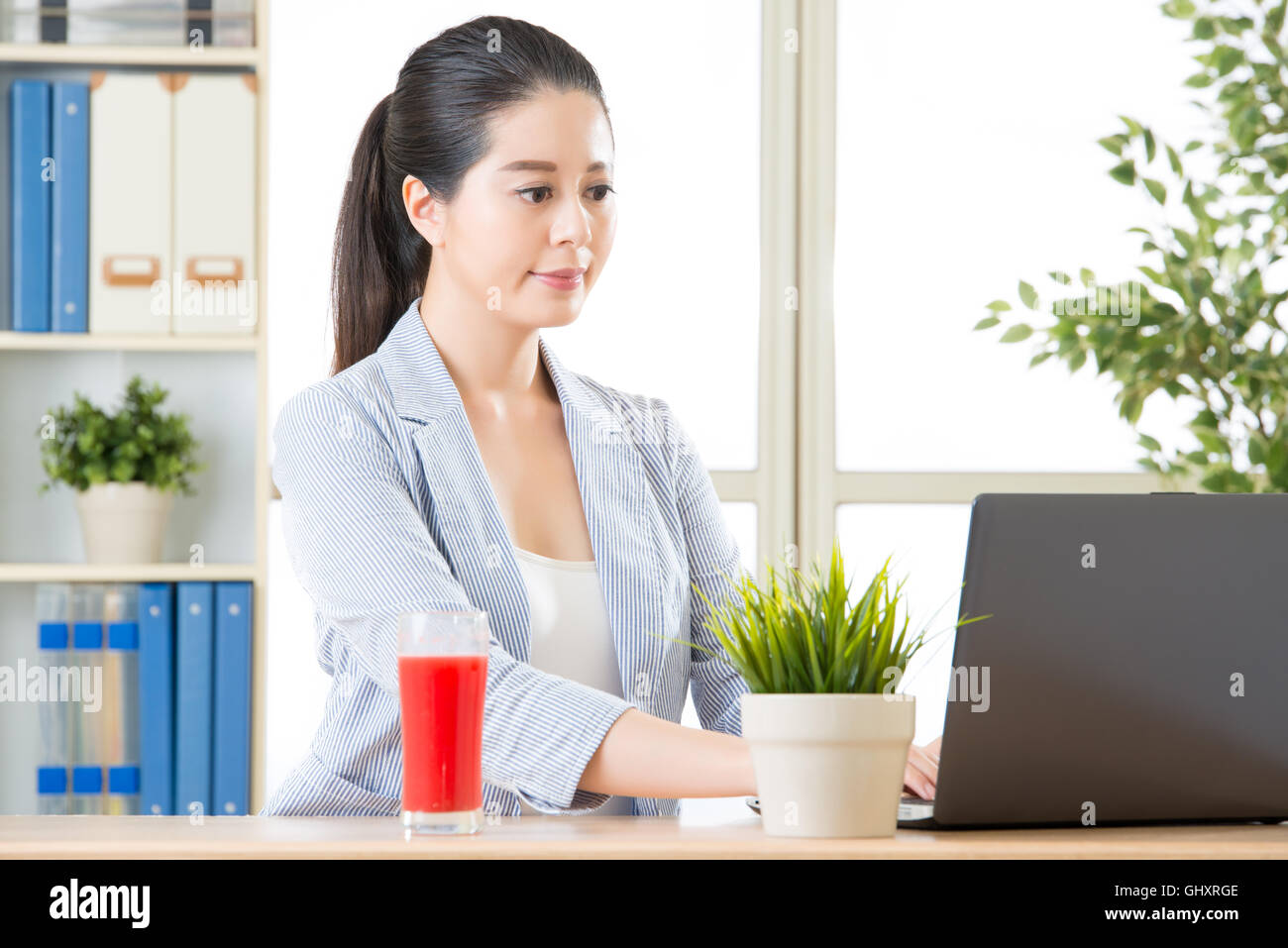 asian business woman using computer and drinking fresh watermelon juice ...